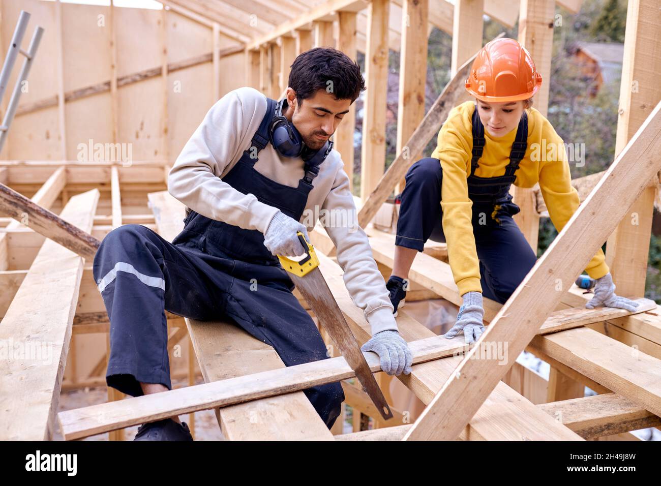 Carpenters saw boards for building house with hand saw. sawing wood ...