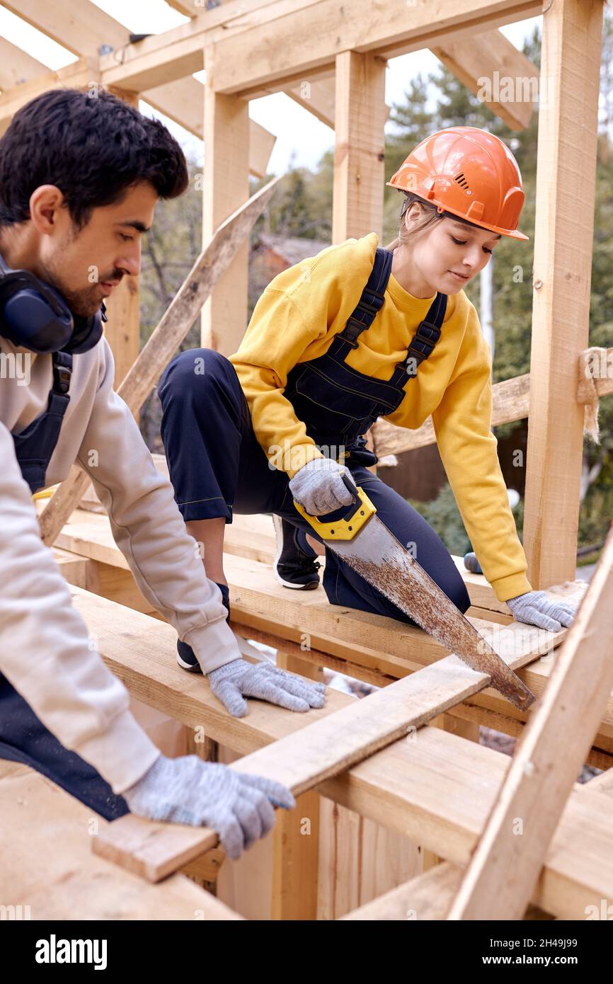 Carpenters saw boards for building house with hand saw. sawing wood ...