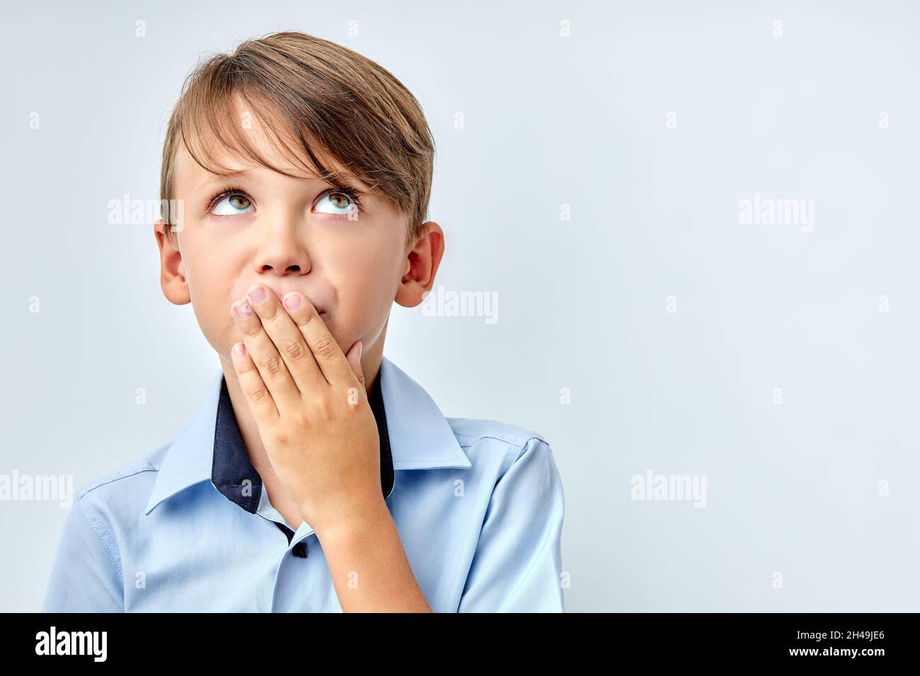 wow. shocked boy closing mouth by surprise, looking up, wondering ...