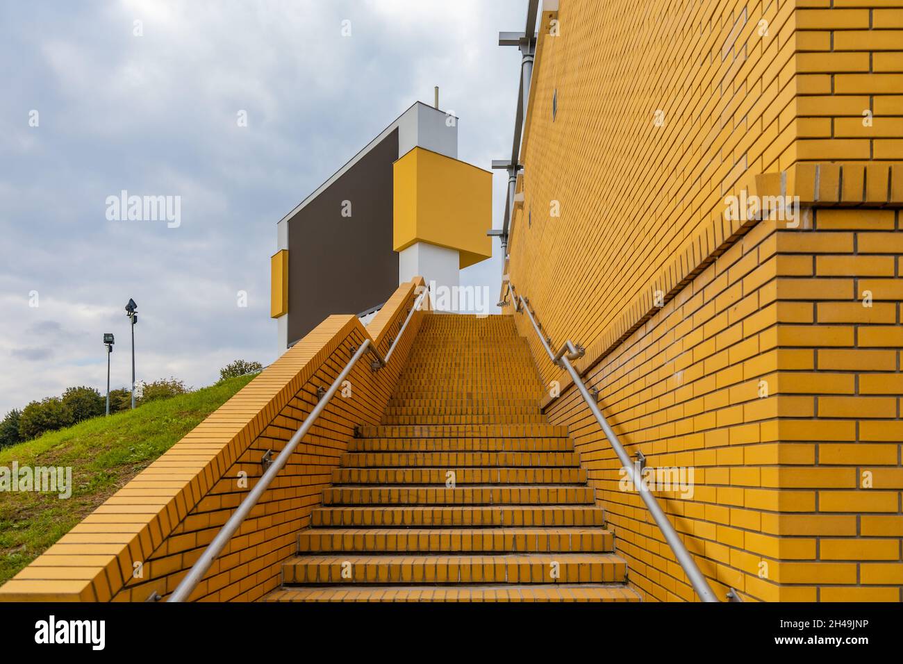 Long yellow brick stairs to place with big totem with big black screen ...