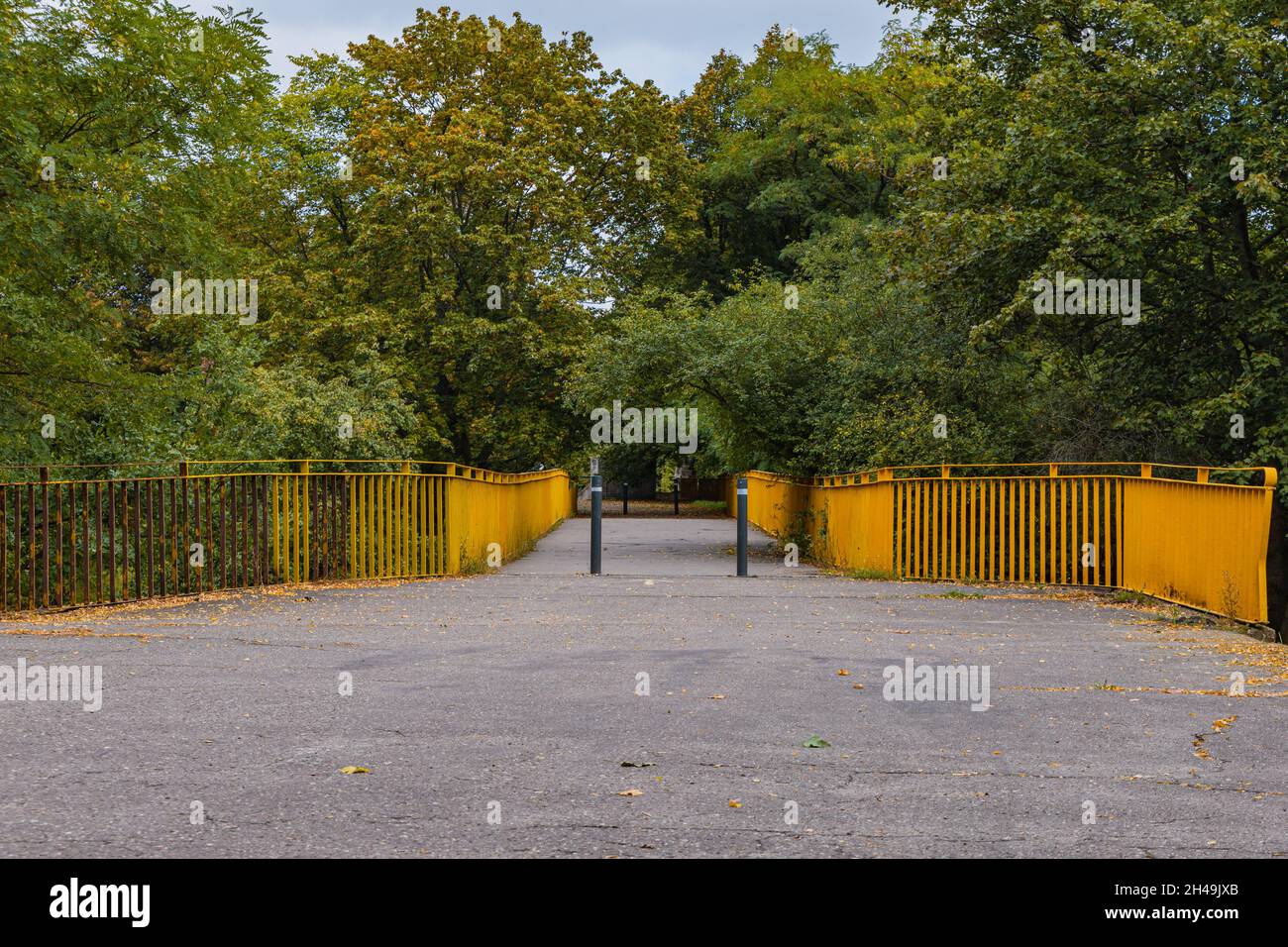 Small concrete bridge with yellow railings and trees around Stock Photo ...