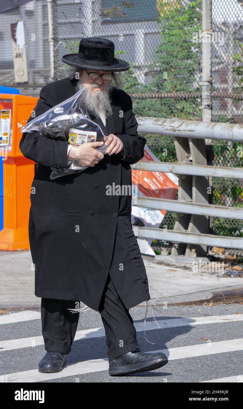 An older orthodox Jewish man returns from synagogue services holding ...