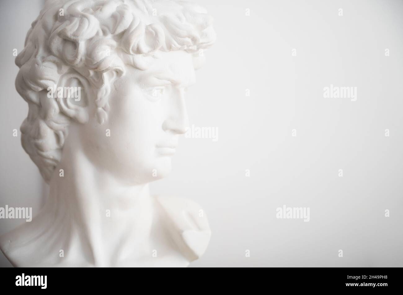 White gypsum statue of men head on light background with copy space ...