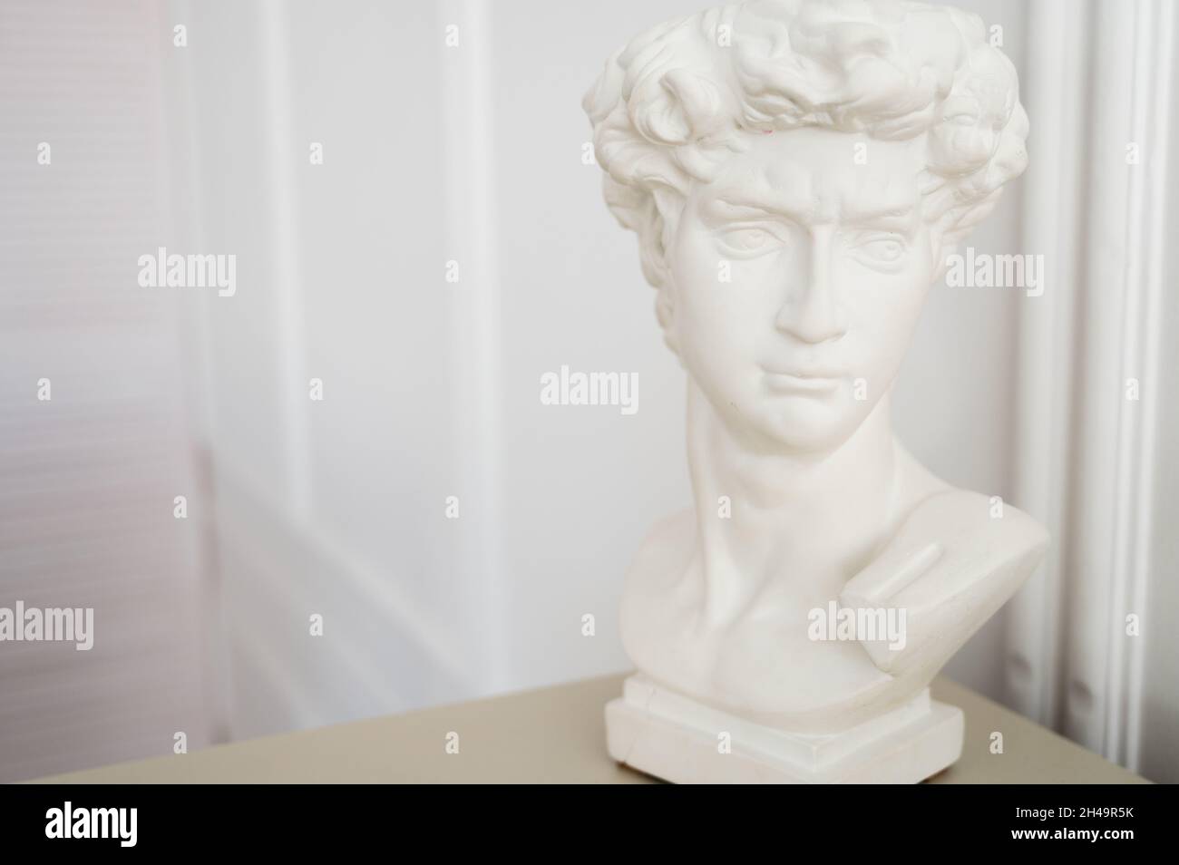 White gypsum statue of men head on light background with copy space ...