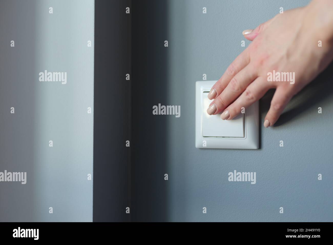 Female hand pressing light switch in apartment closeup Stock Photo - Alamy