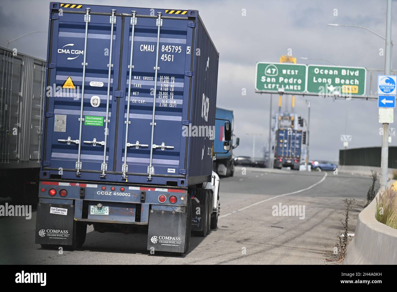 Trucks haul shipping containers at the Port of Los Angeles on October ...