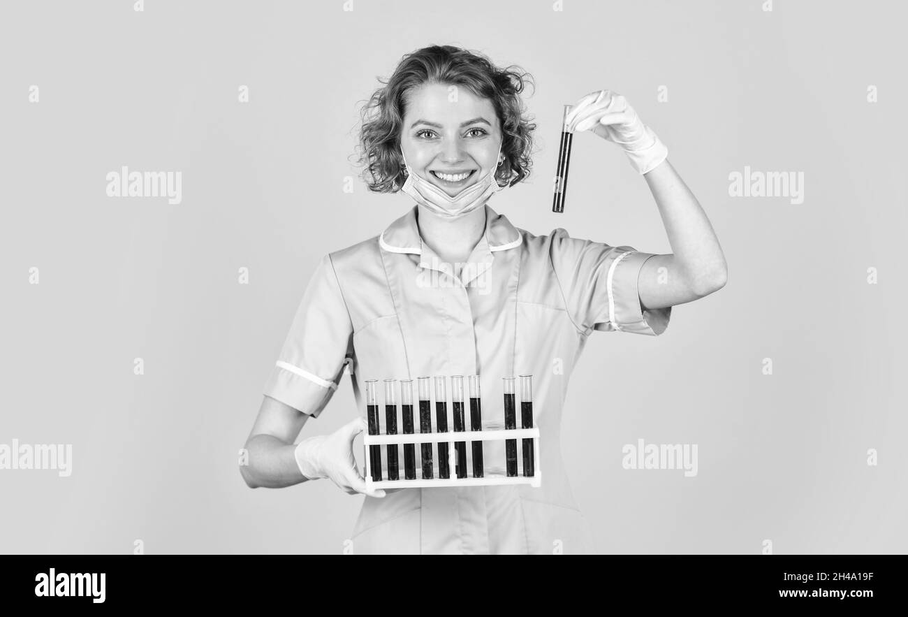 Test your blood. scientist in face mask and gloves holding test tube ...