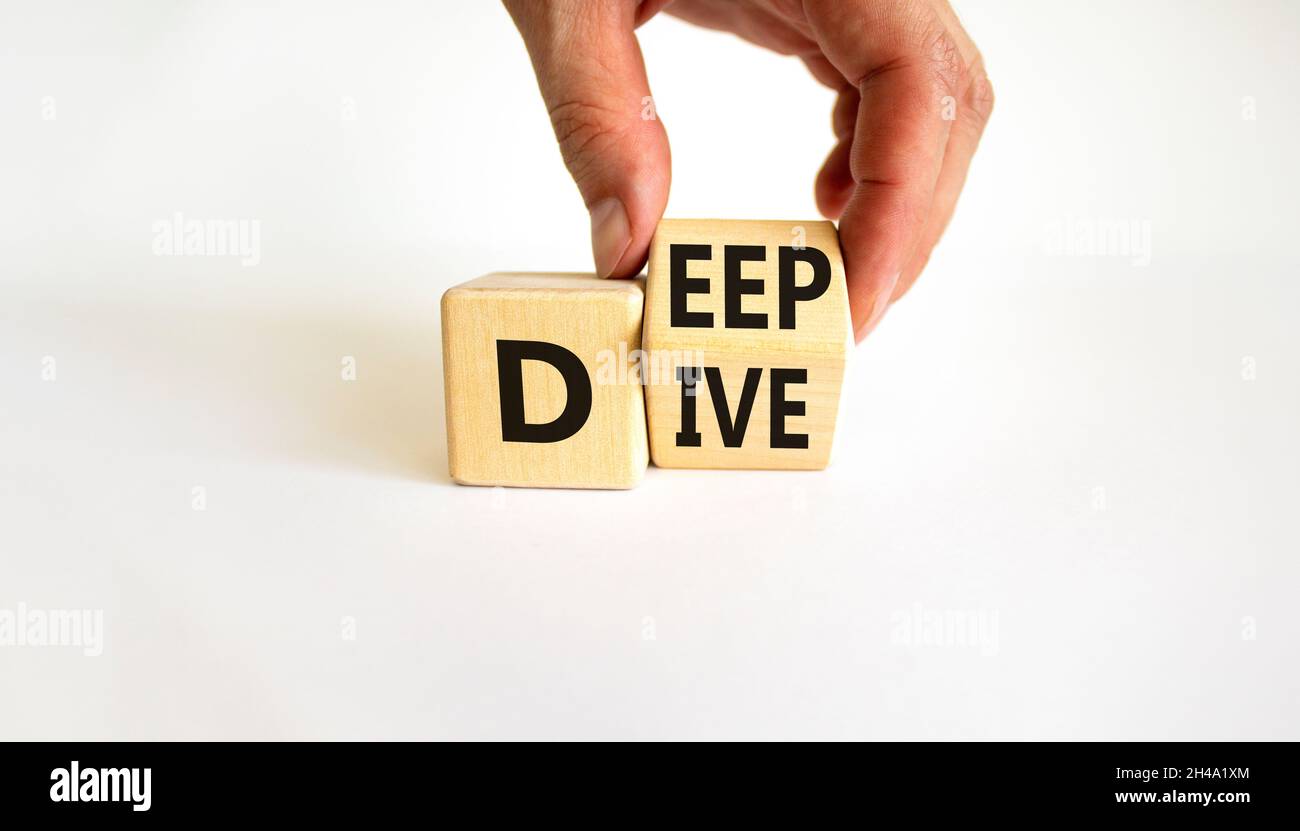Deep dive symbol. Businessman turns a wooden cube with words 'Deep dive ...