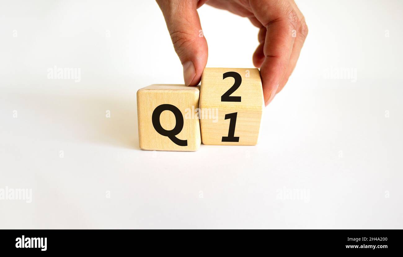 From 1st to 2nd quarter symbol. Businessman turns a wooden cube and ...