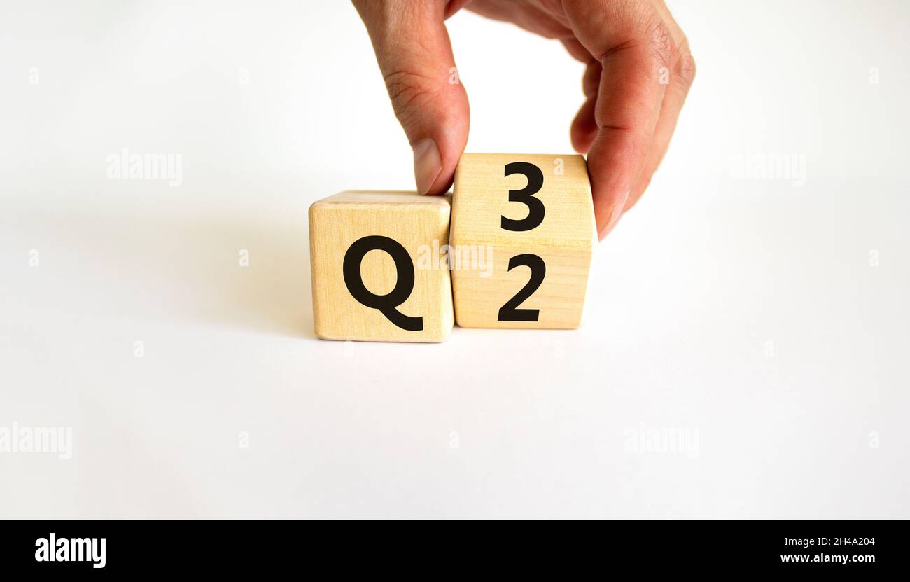 From 2nd to 3rd quarter symbol. Businessman turns a wooden cube and ...