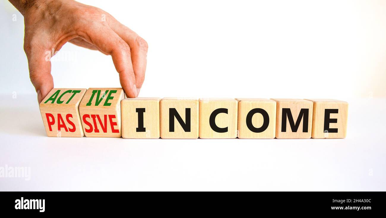 Passive or active income symbol. Businessman turns wooden cubes and ...