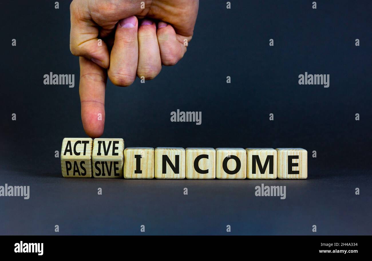 Passive or active income symbol. Businessman turns wooden cubes and ...