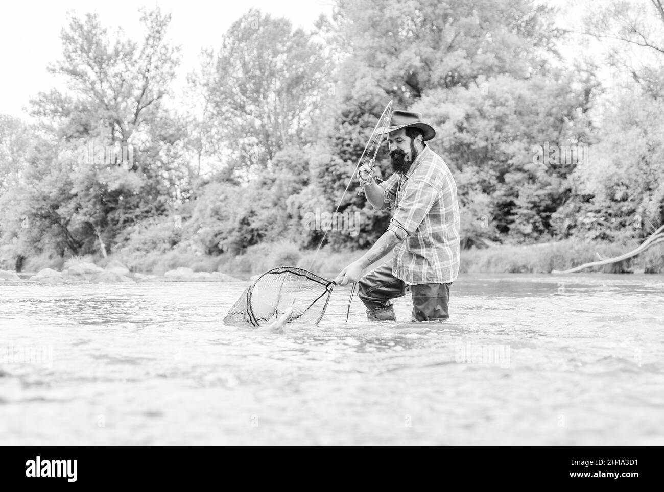 At Retirement. Happy bearded fisher in water. mature man fly fishing ...