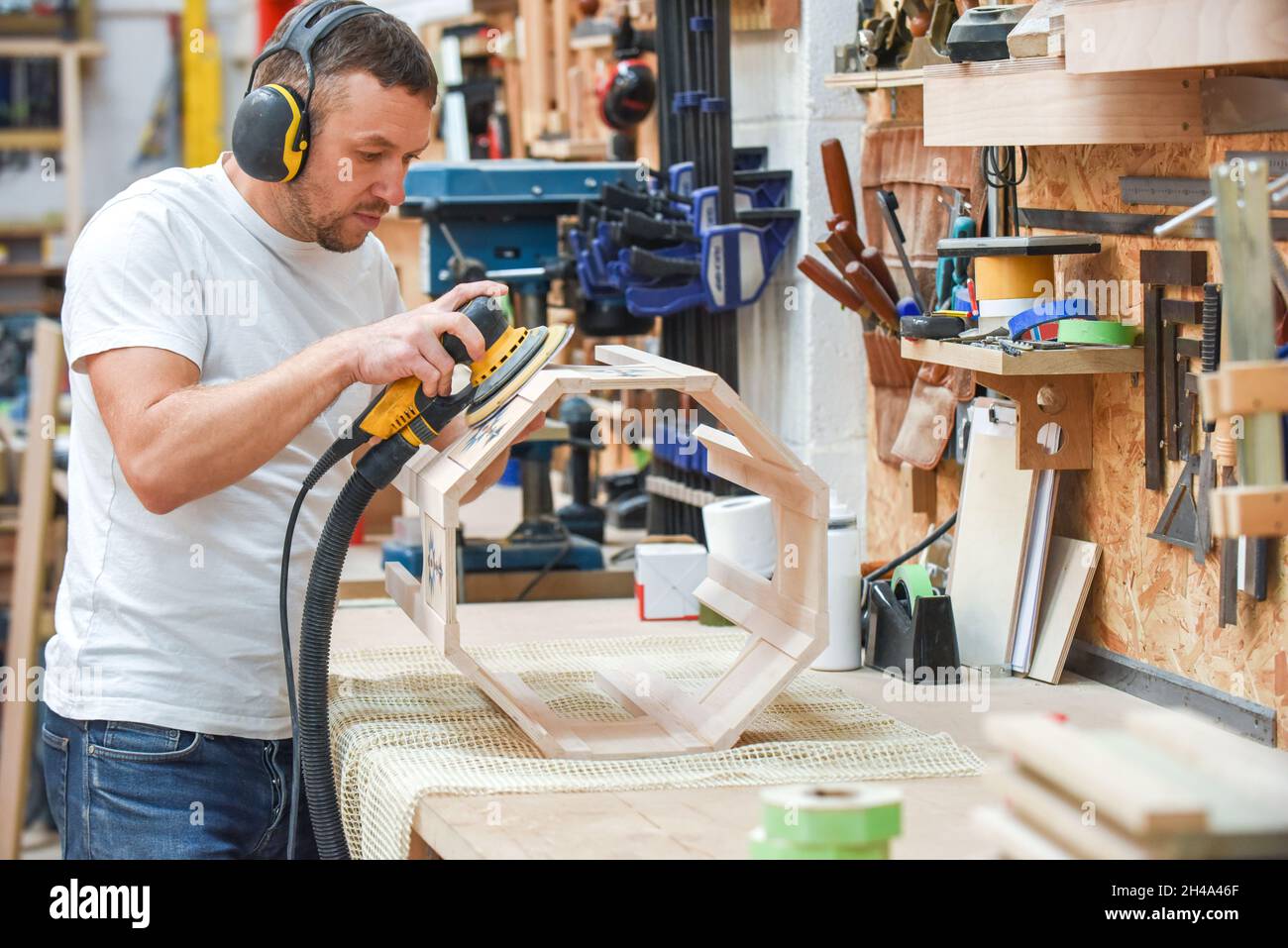 A man is making bespoke furniture in a woodwork workshop showing the ...