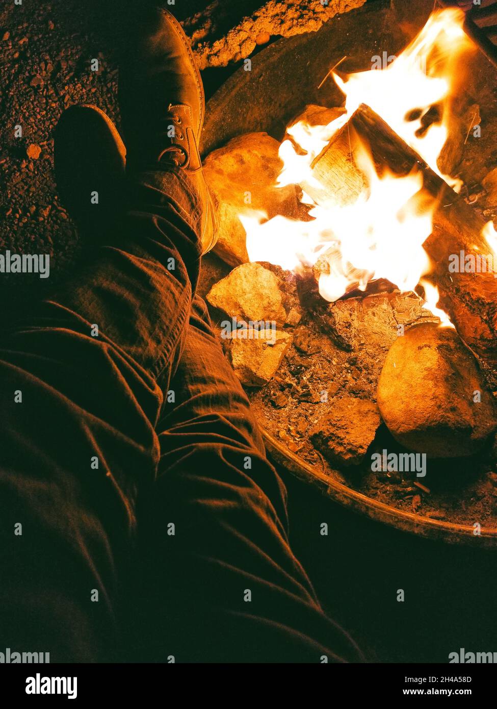 Vertical shot of human legs and a fire pit at night Stock Photo - Alamy