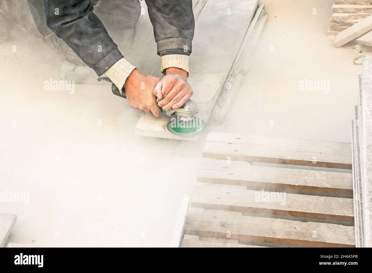 A man polishes a granite slab with a grinder. Work on stone with an ...