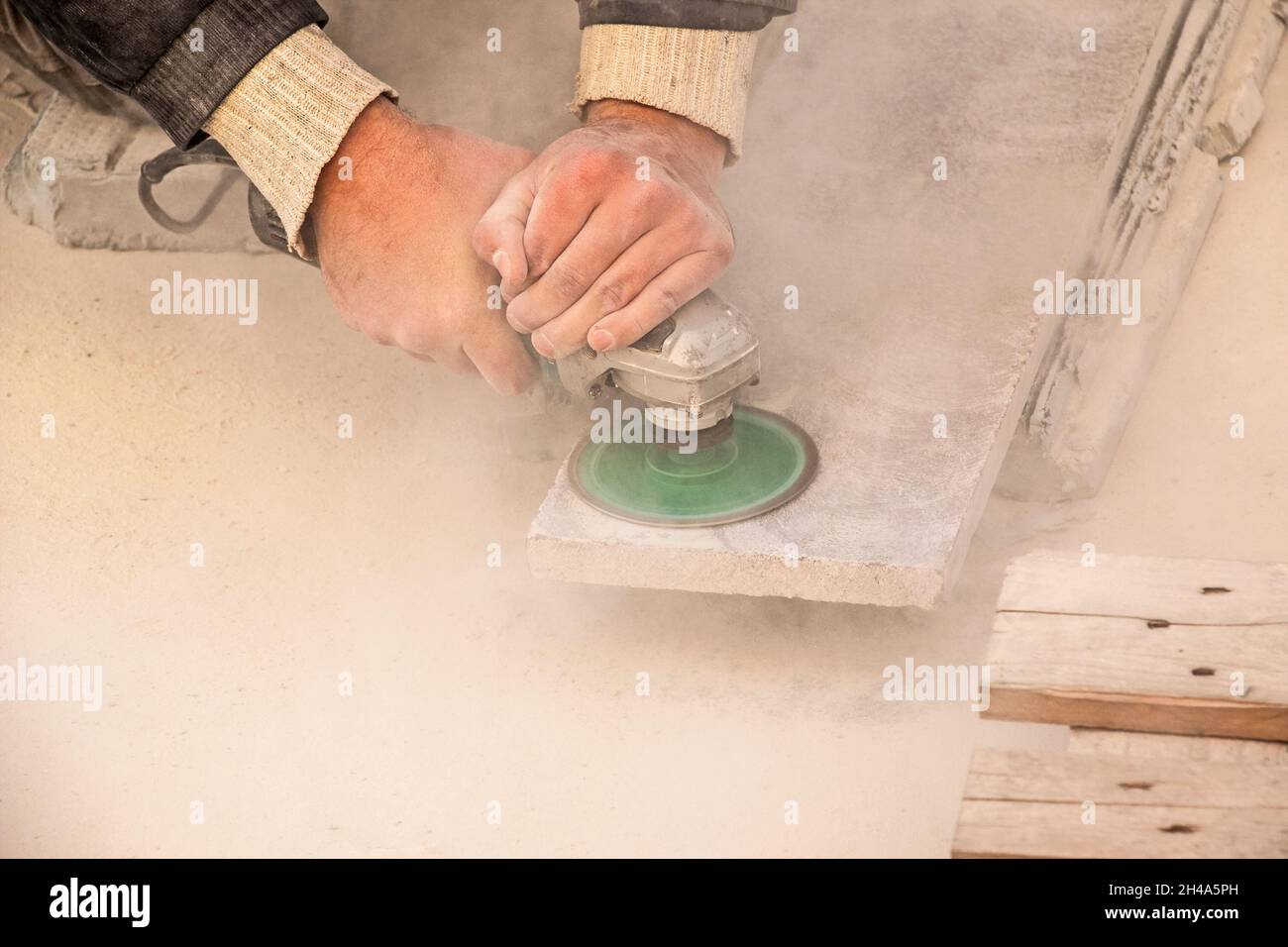 A man polishes a granite slab with a grinder. Work on stone with an ...