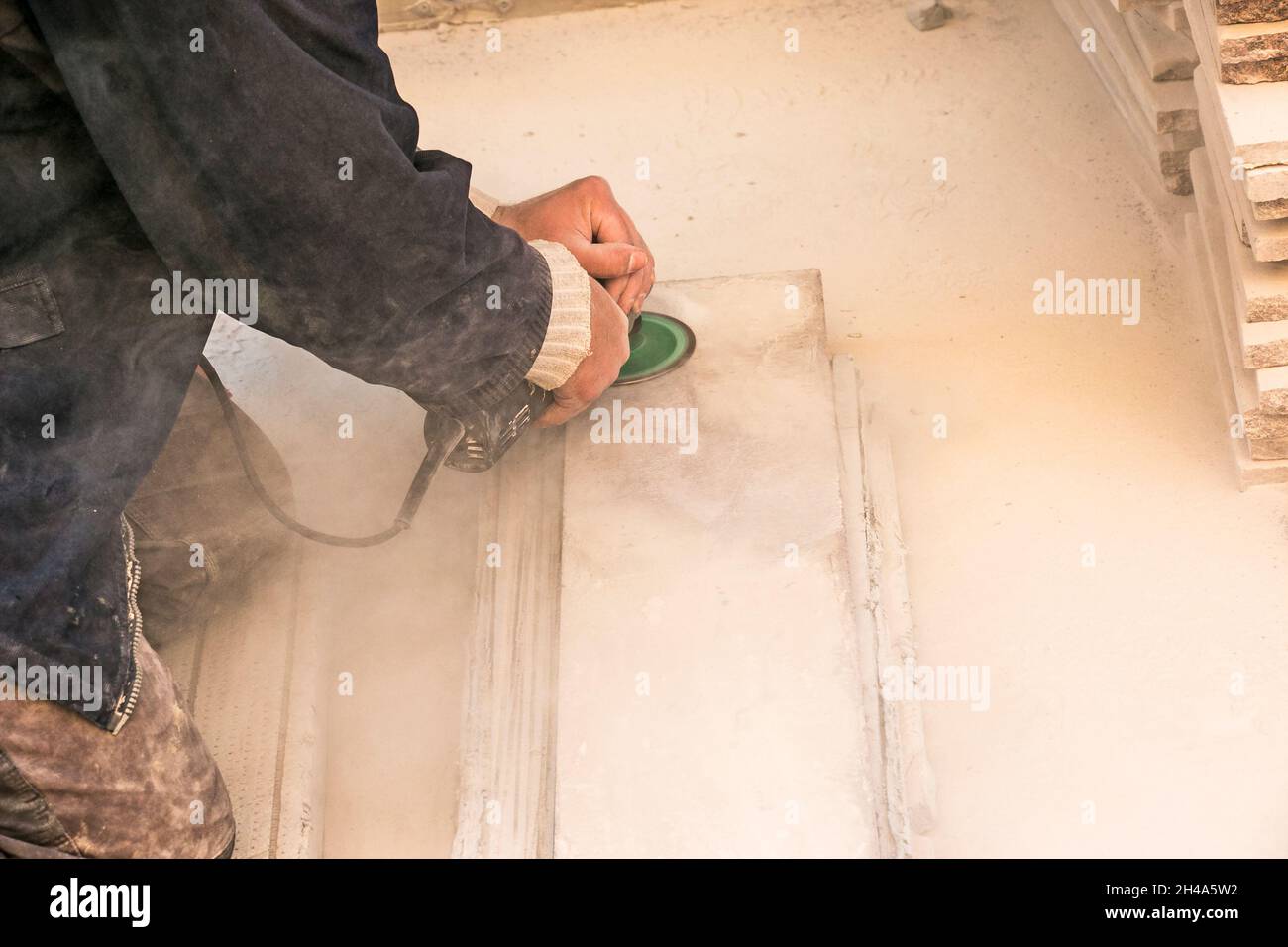 A man polishes a granite slab with a grinder. Work on stone with an ...