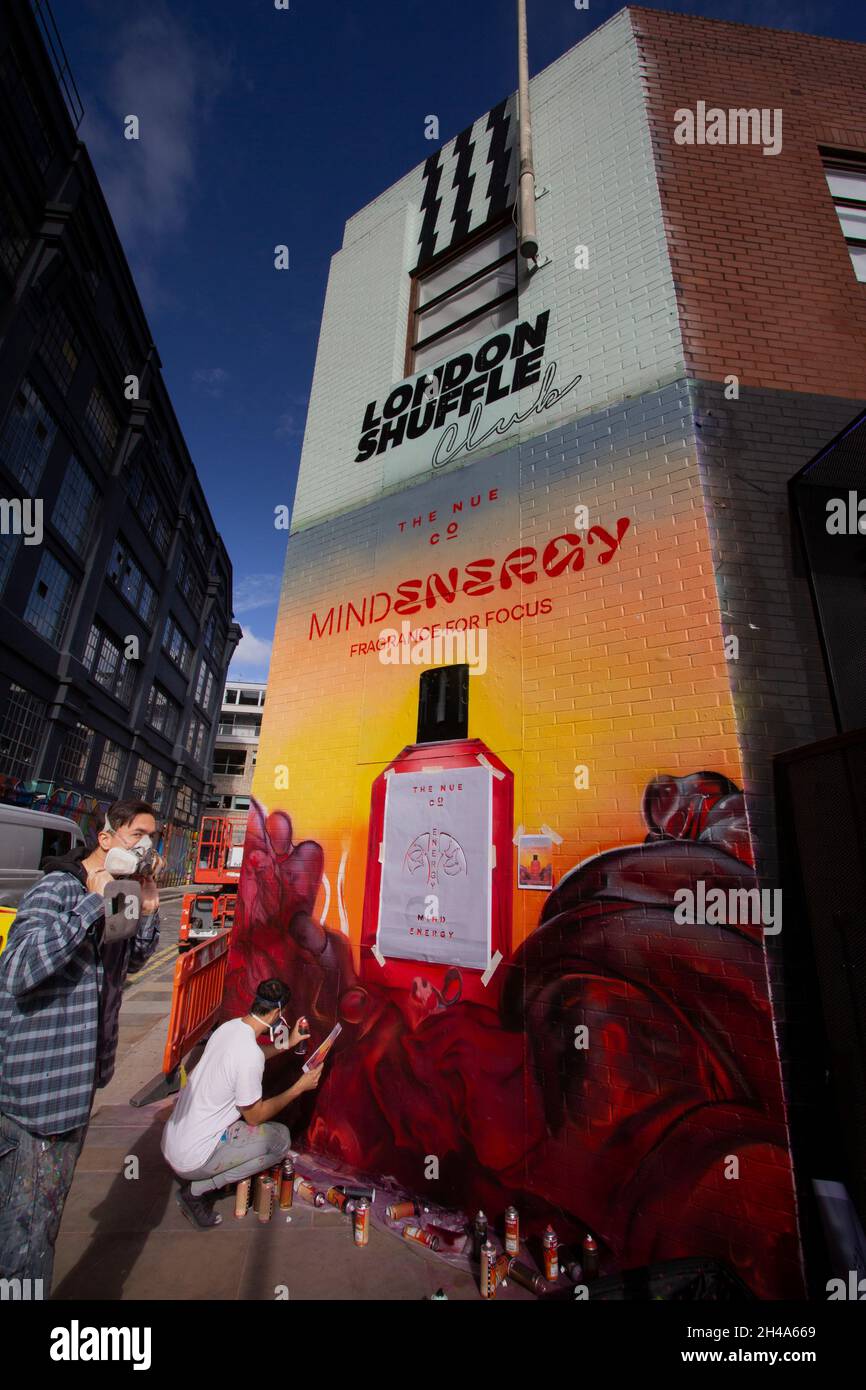 Graffiti artists decorating the wall of the London Shuffle Club ...