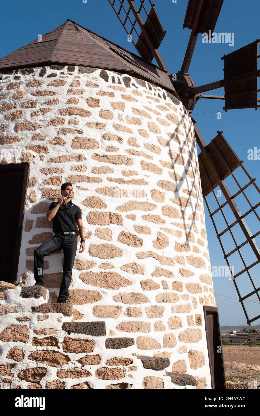 man leaning on the wall of a windmill Stock Photo - Alamy