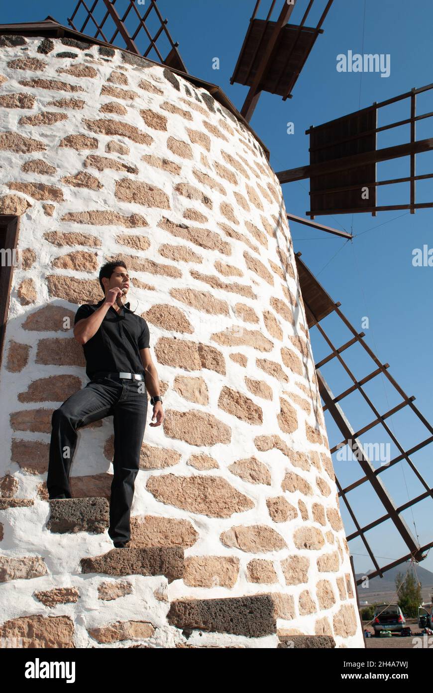 man leaning on the wall of a windmill Stock Photo - Alamy
