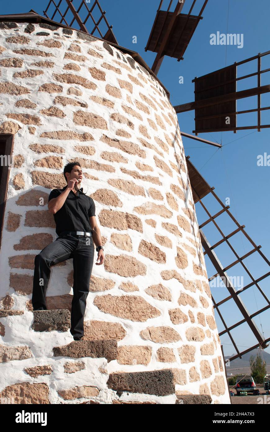 man leaning on the wall of a windmill Stock Photo - Alamy