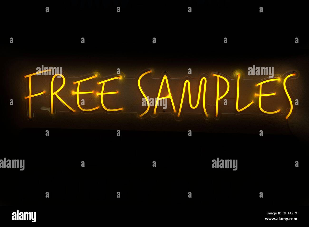 A "Free Samples" neon sign glows in a window of a shop selling honey in ...