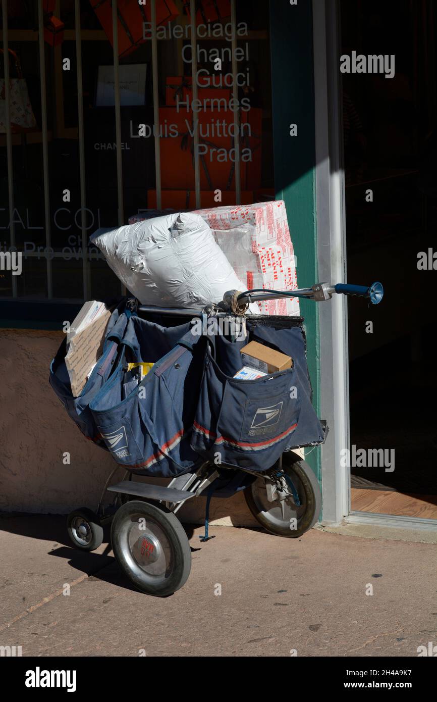 A female U.S. mailman delivers letters and packages using a US Postal ...