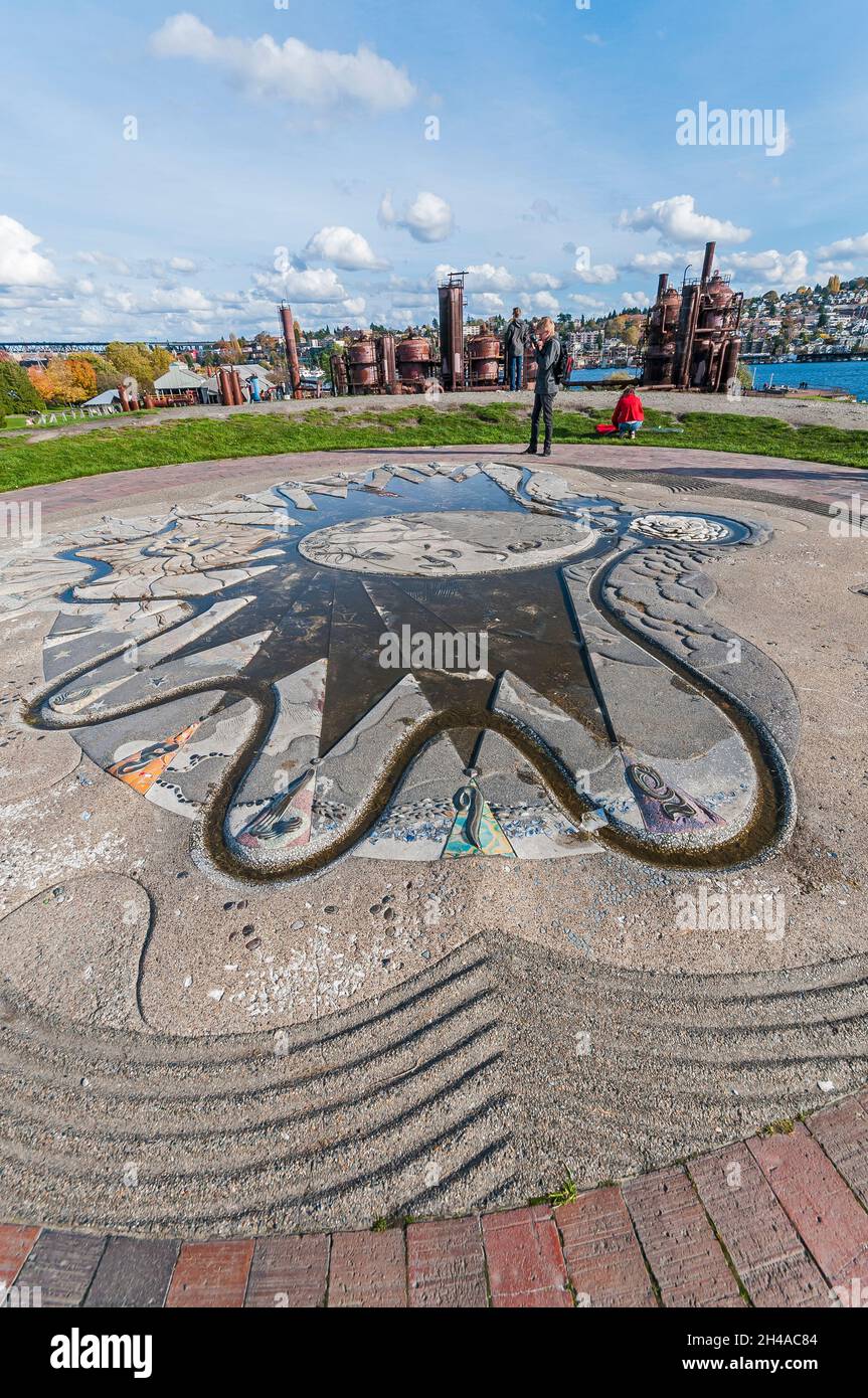 A photographer and others enjoying a day at the large concrete sundial ...