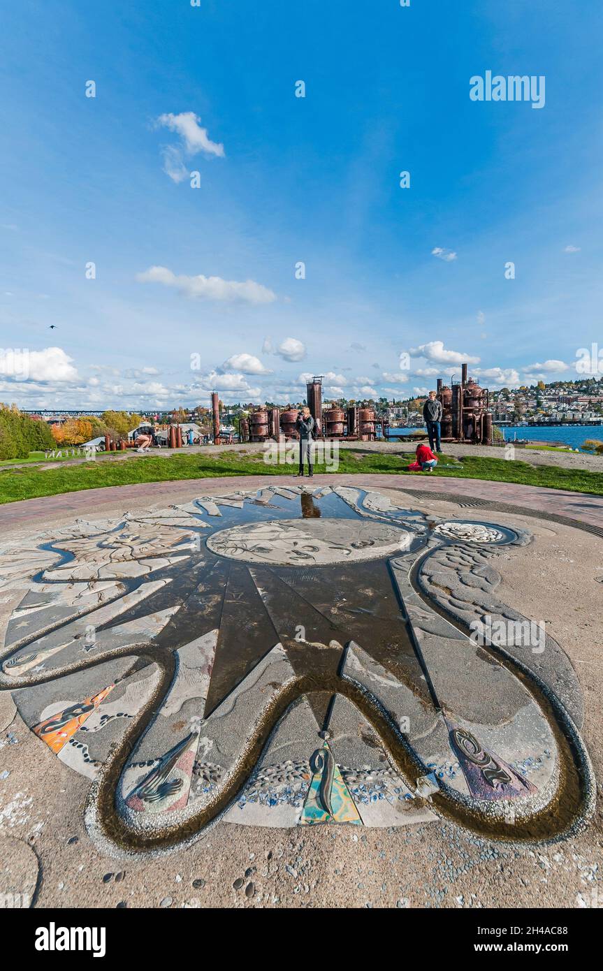 A photographer and others enjoying a day at the large concrete sundial ...
