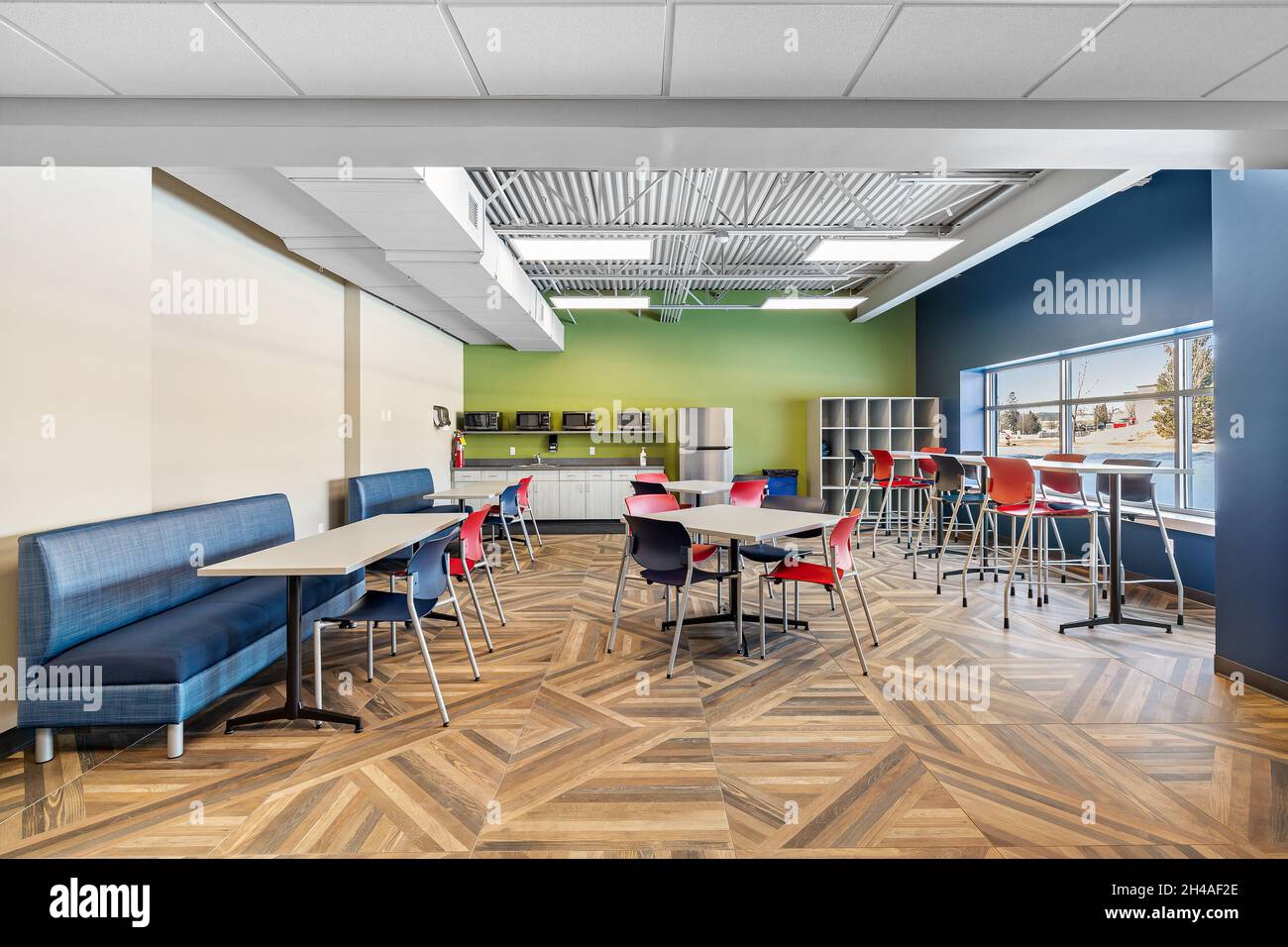 A colorful office break room with a hardwood floor, colorful chairs ...
