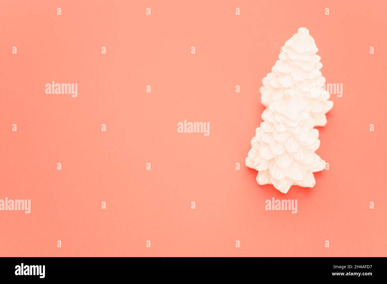 white decorative wax fir trees on a salmon pink background with Stock ...