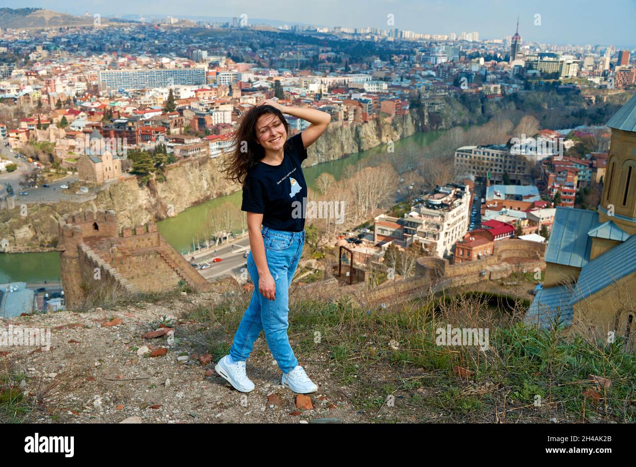 A cute brunette girl enjoys the stunning scenery of Tbilisi from the ...