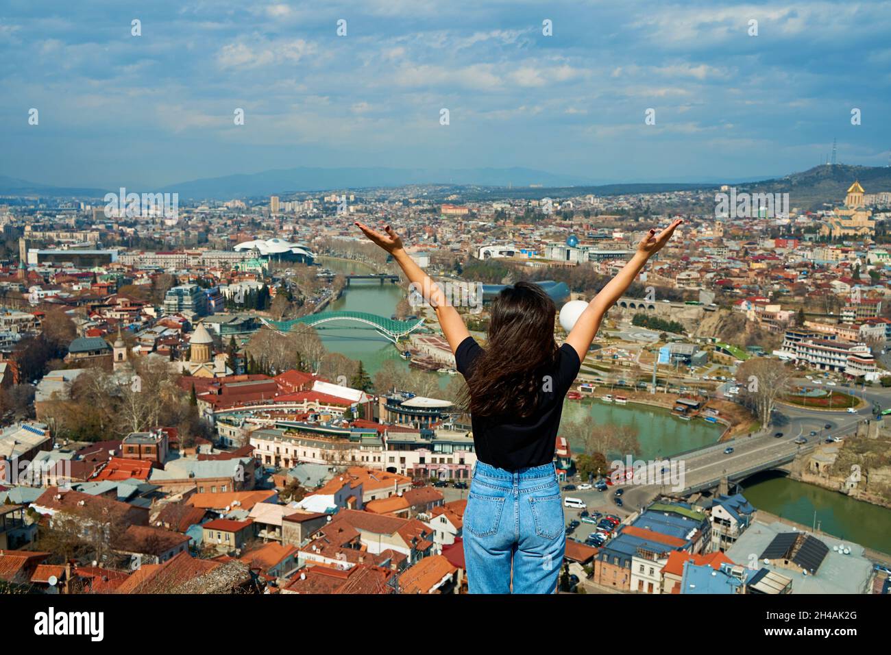 A cute brunette girl enjoys the stunning scenery of Tbilisi from the ...