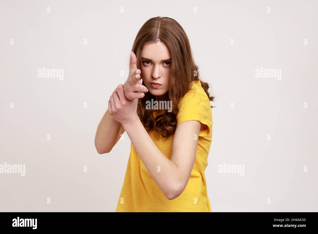 I'll kill you. Portrait of angry teenager girl in yellow T-shirt ...