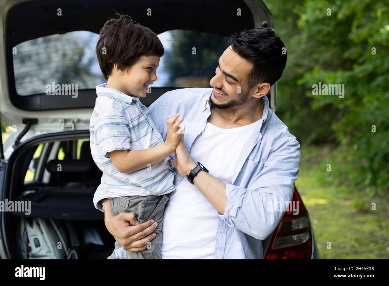 Portrait Of Happy Arab Man And His Little Son Standing Near Car With ...