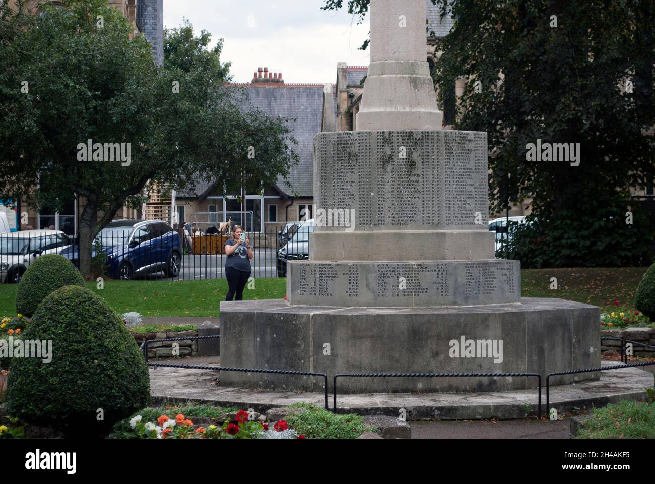 Woman taking photograph of War Memorial in Hexham Park, Hexham ...