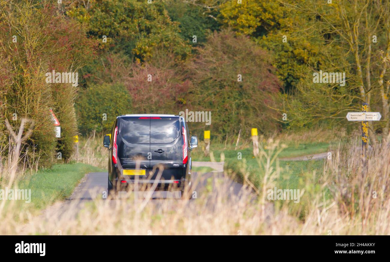 black Ford Transit Custom van driving through scenic autumnal ...