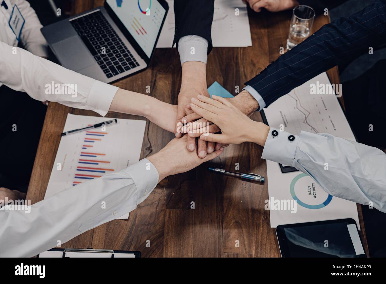 High angle shot of business partners putting their hands together ...