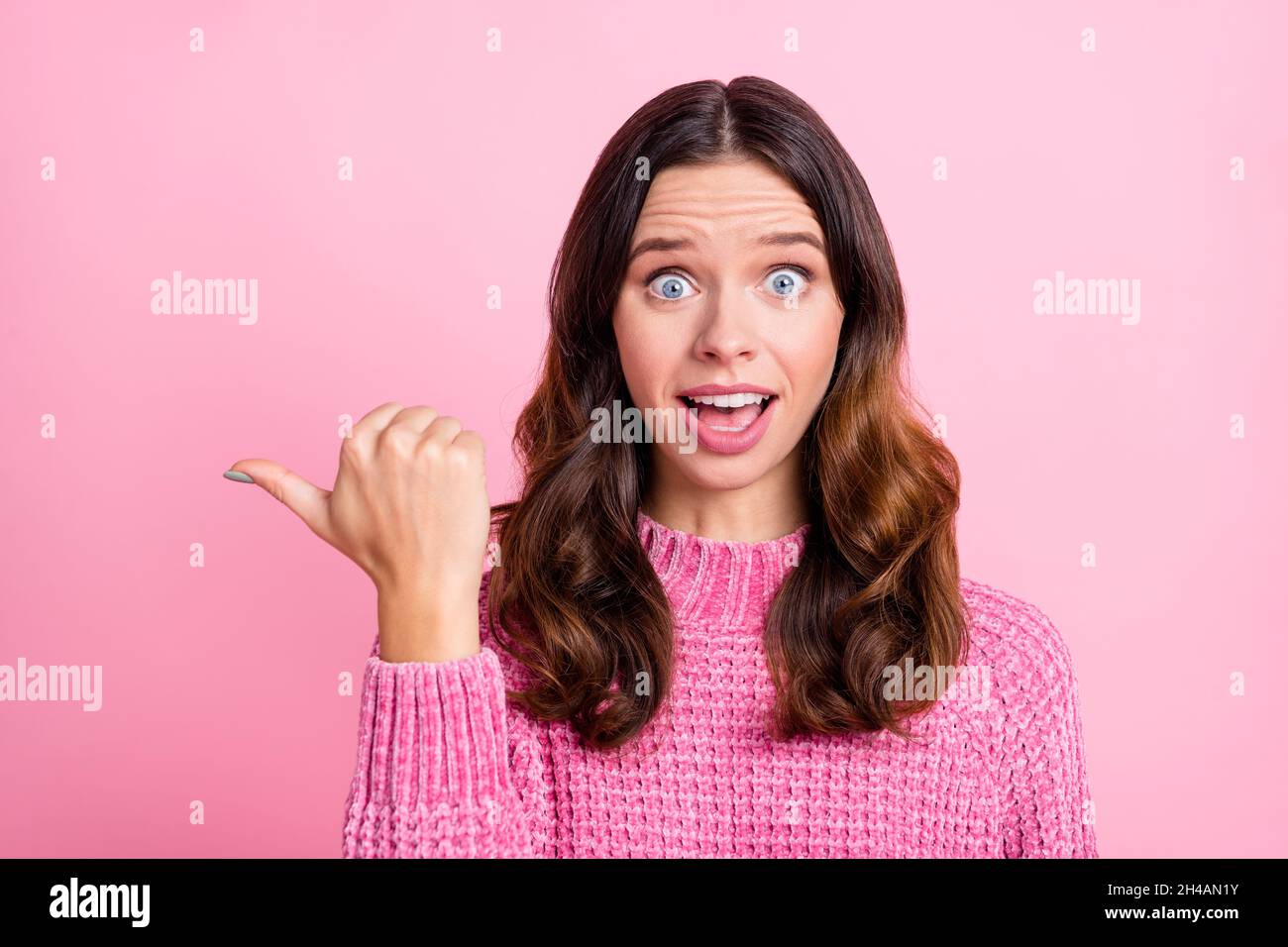 Photo Of Impressed Brunette Lady Point Empty Space Wear Pink Sweater