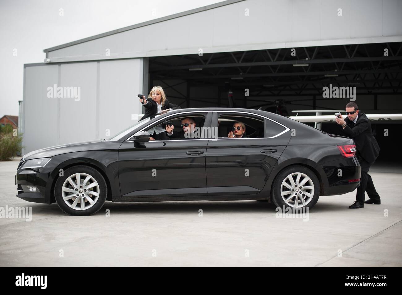 Professional armed team of female and male bodyguards protect celebrity ...