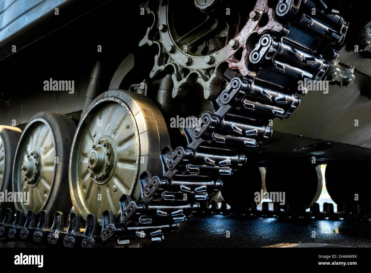 Tracked armor close-up. Black link tracks and large rubberized rollers ...