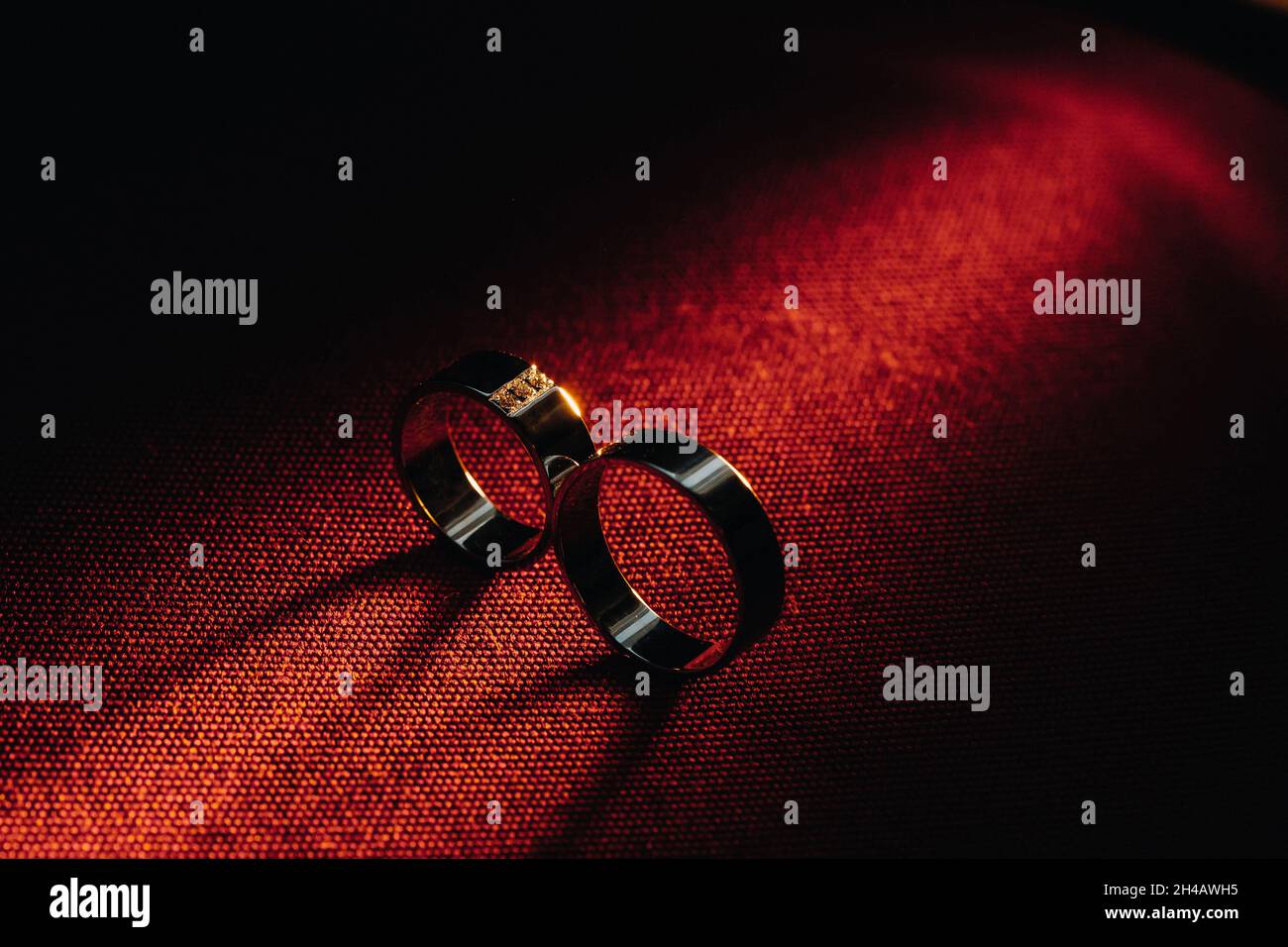 Two wedding rings on a red background. Gold rings of a couple in love ...