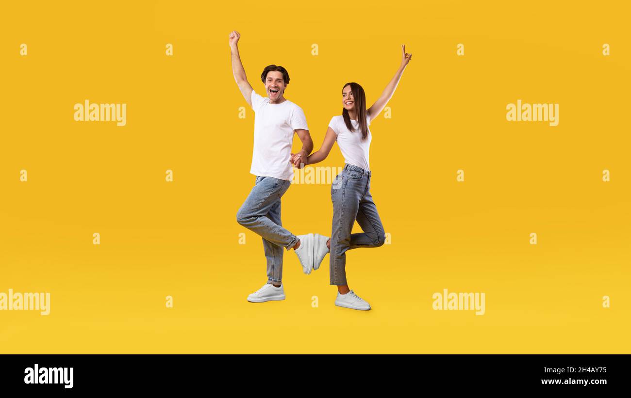 Wow, Yes. Portrait of overjoyed young couple holding hands, excited guy ...