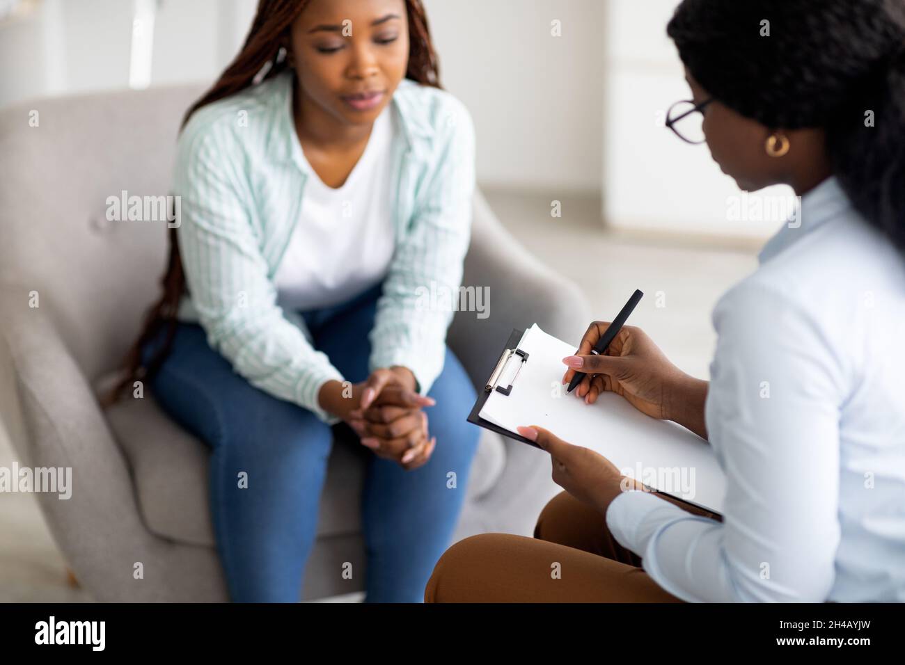 Stressed black female patient consulting psychologist at medical office ...