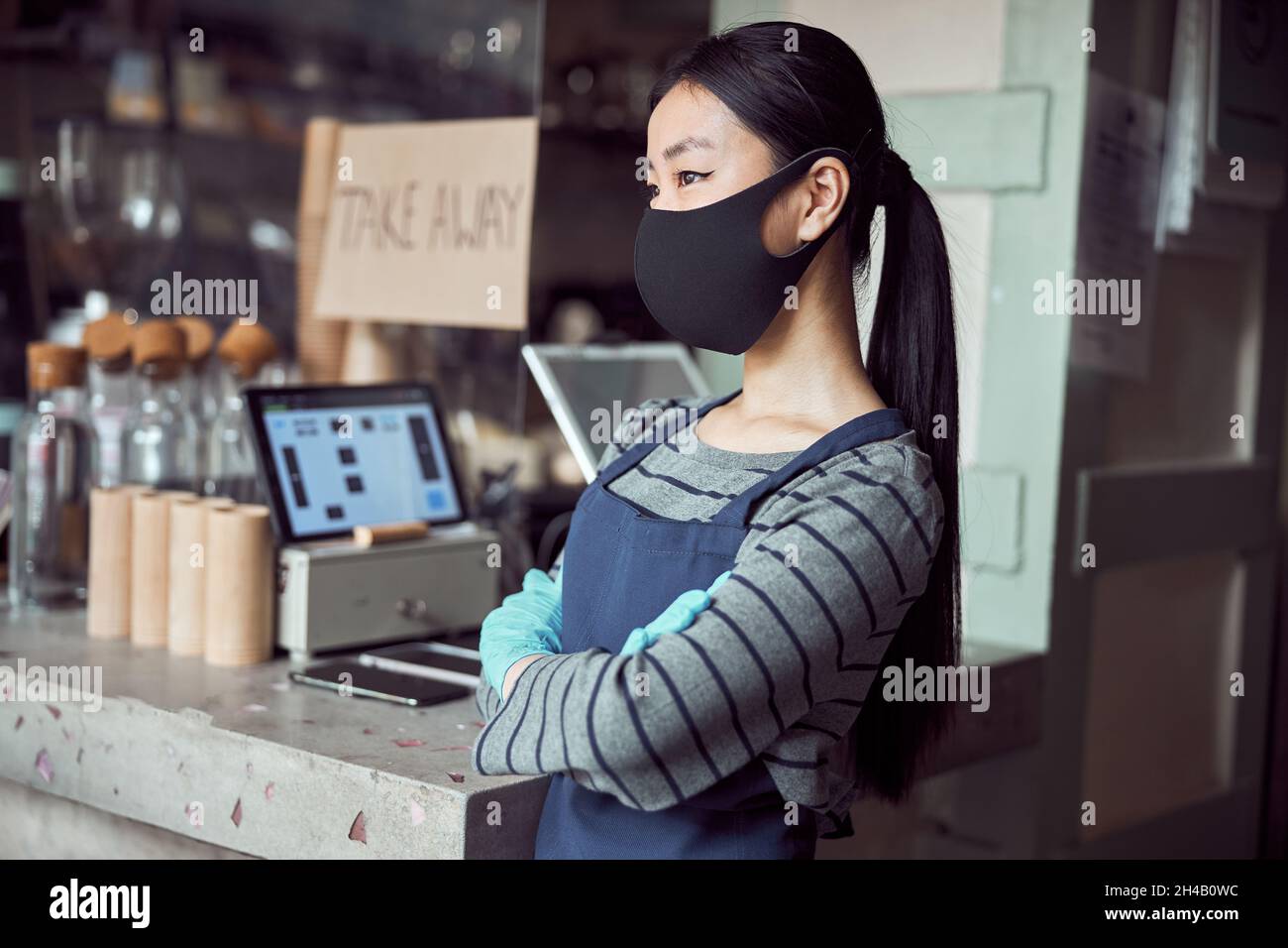 Young waitress waiting for clients inside coffee shop Stock Photo - Alamy