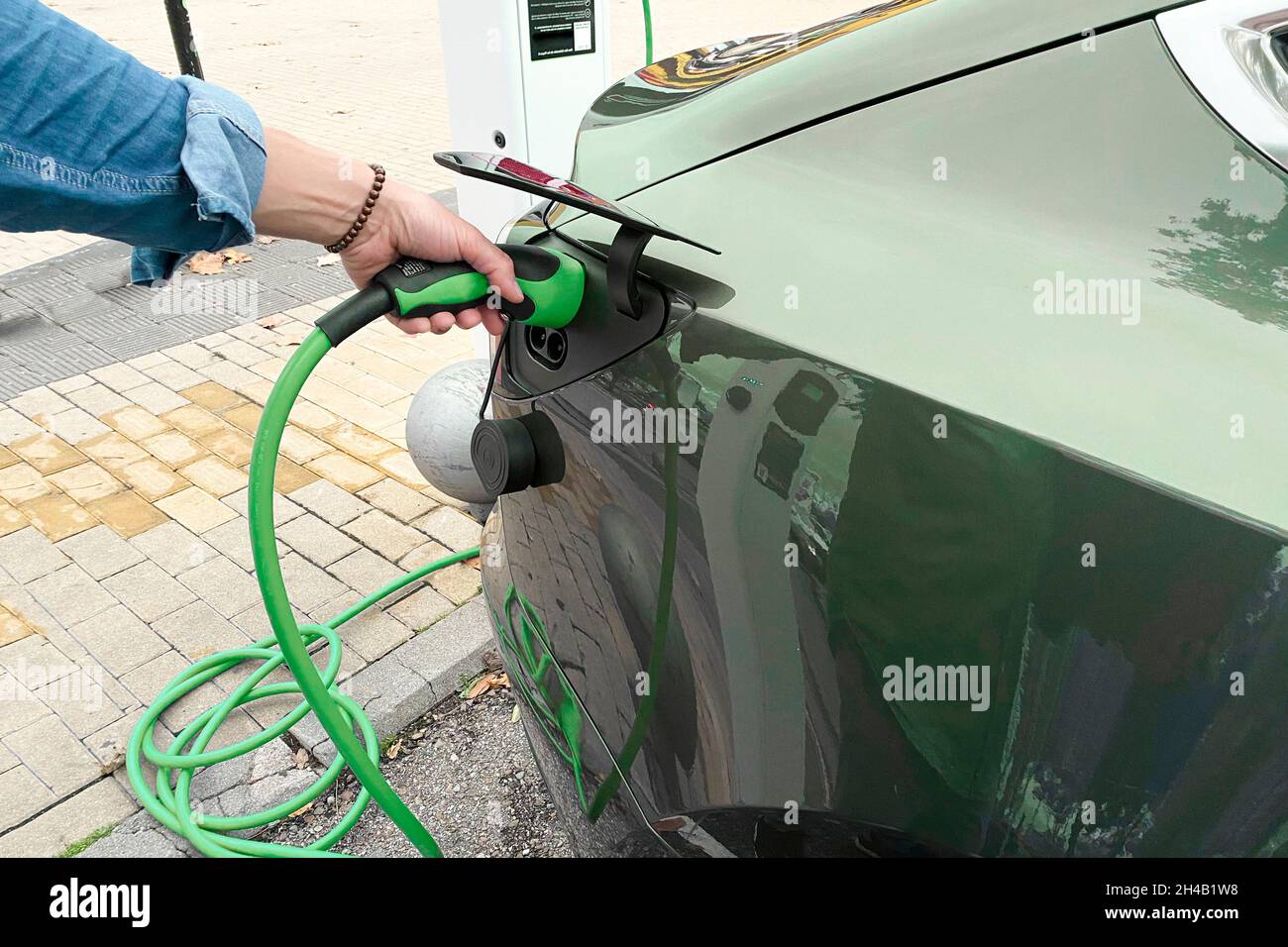 Person connecting an electric car. Technology electric vehicle concept ...