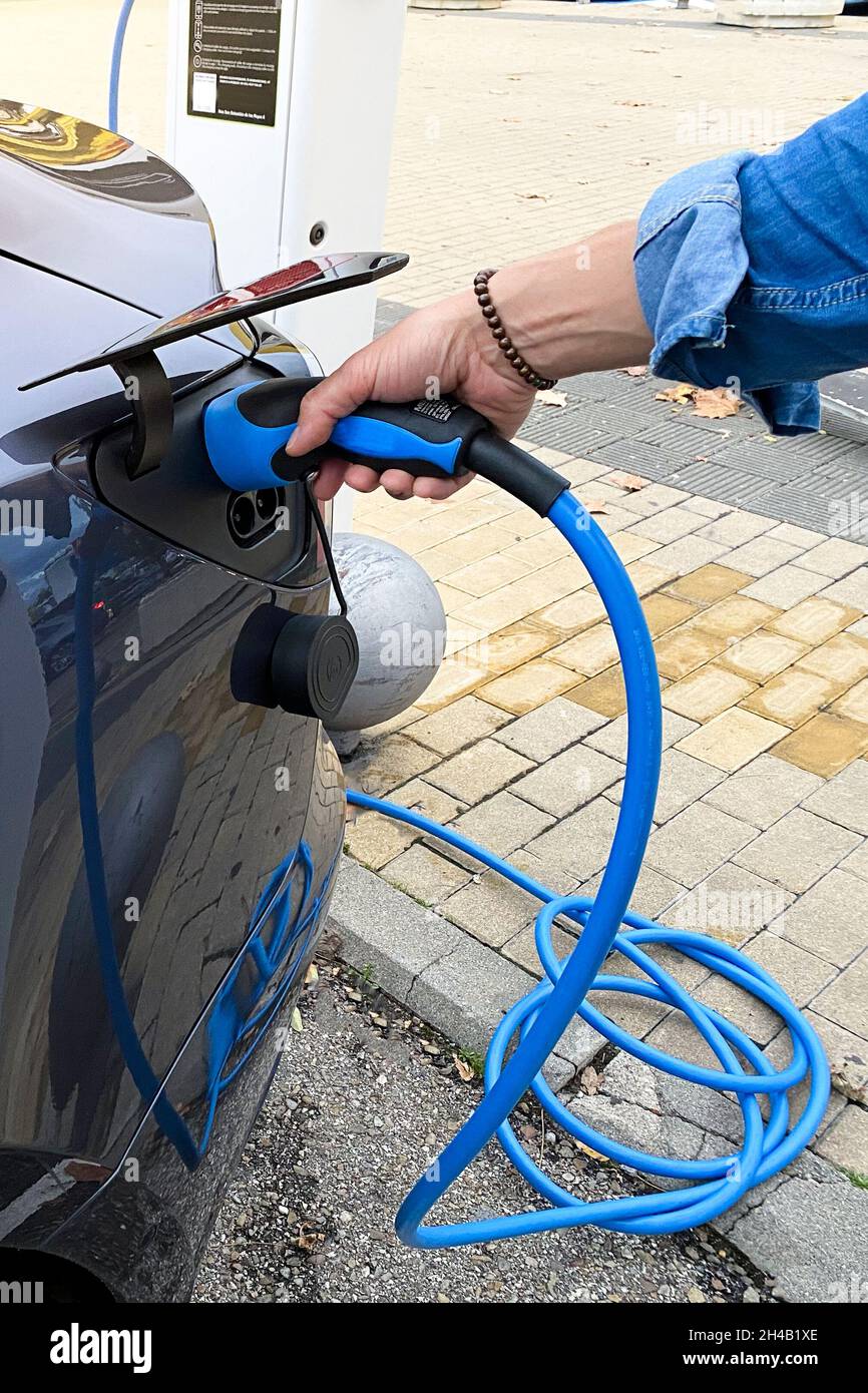 Person connecting an electric car. Vertical photography. Technology ...