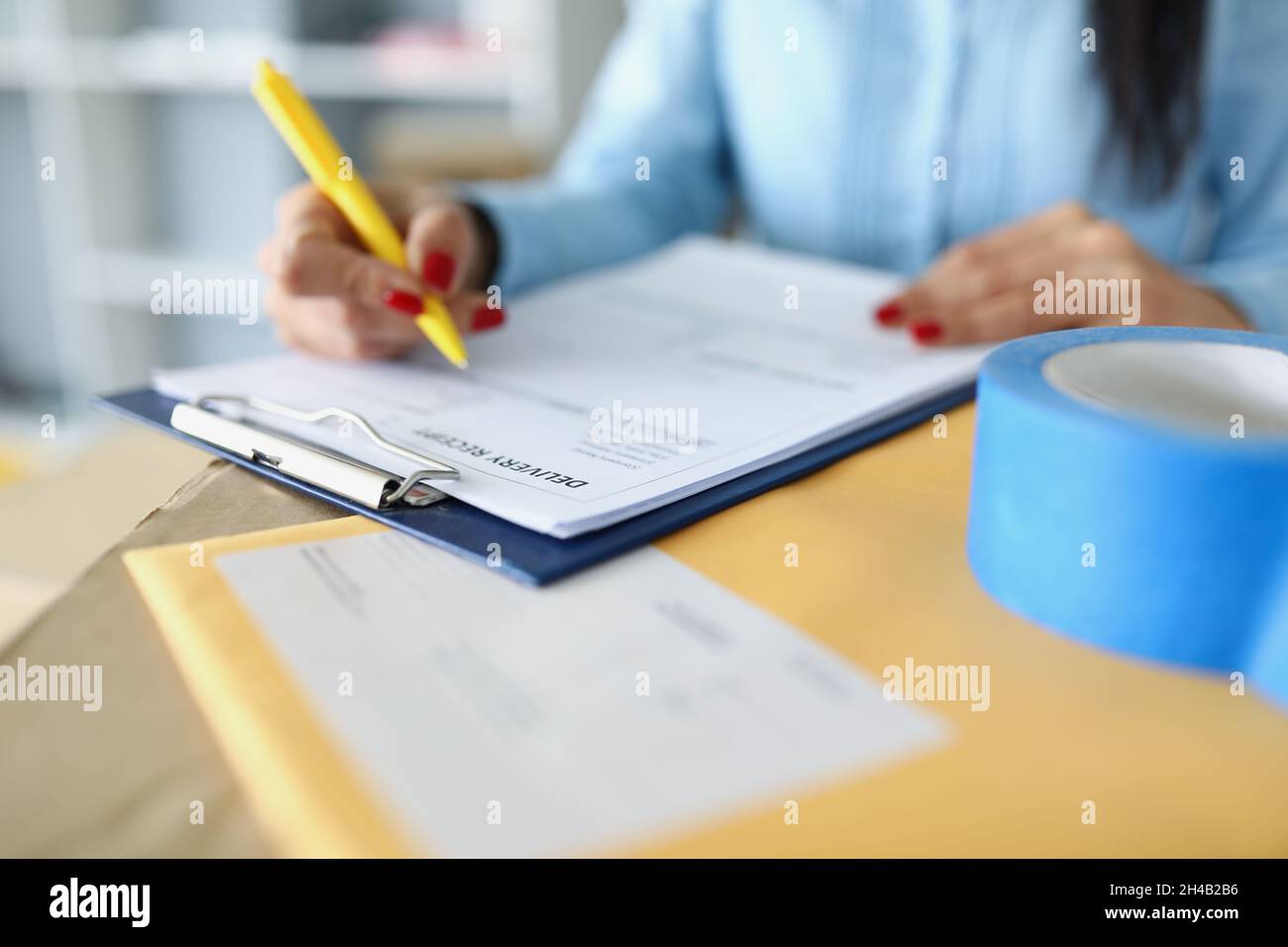 Woman holding bright yellow pen Stock Photo - Alamy