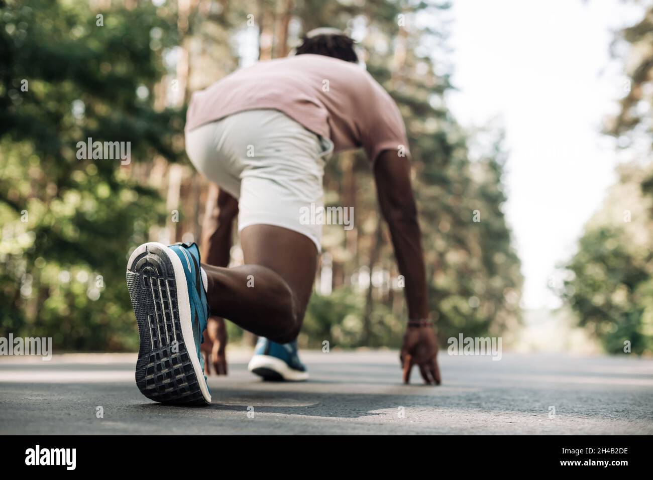 Fit black male sprinter, in starting position ready to run, Male ...